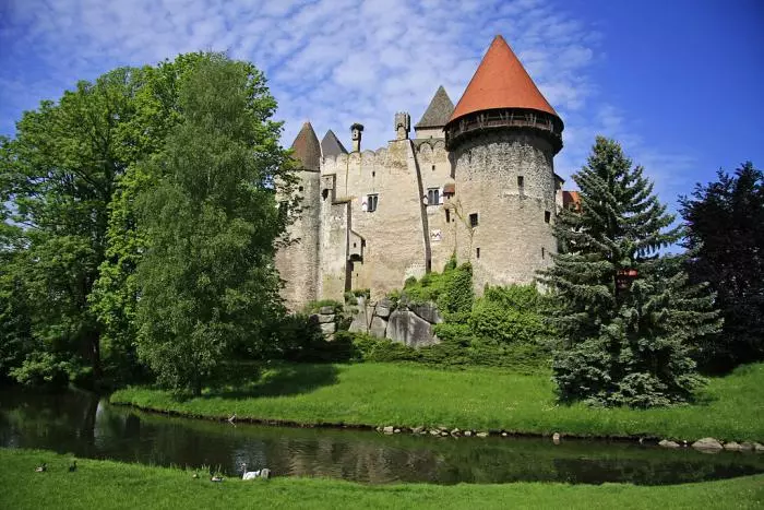 Austrian Castle Heidenraichstein, in der Nähe der Grenze zu Böhmen. Das Schloss ist auf einer relativ glatten Gegend gebaut, sodass der Wassergraben umgeben musste. Die von den Rillen umgebenen Schlössern wurden Wasserburg genannt. Das in XII Jahrhundert erbaut, hat das Schloss viele Rekonstruktionen erfahren. Während des 15. Jahrhunderts zögerte, und die Rebellen der Bauern wurden wiederholt belagert. Achten Sie auf die Holzplattform um den Turm, wodurch die Garnison die Basis des Turms beobachten kann. Im XIII Jahrhundert, im Schloss, wurde der Wachturm abgeschlossen (Bergfried), gewöhnlich für deutsche mittelalterliche Burgen.