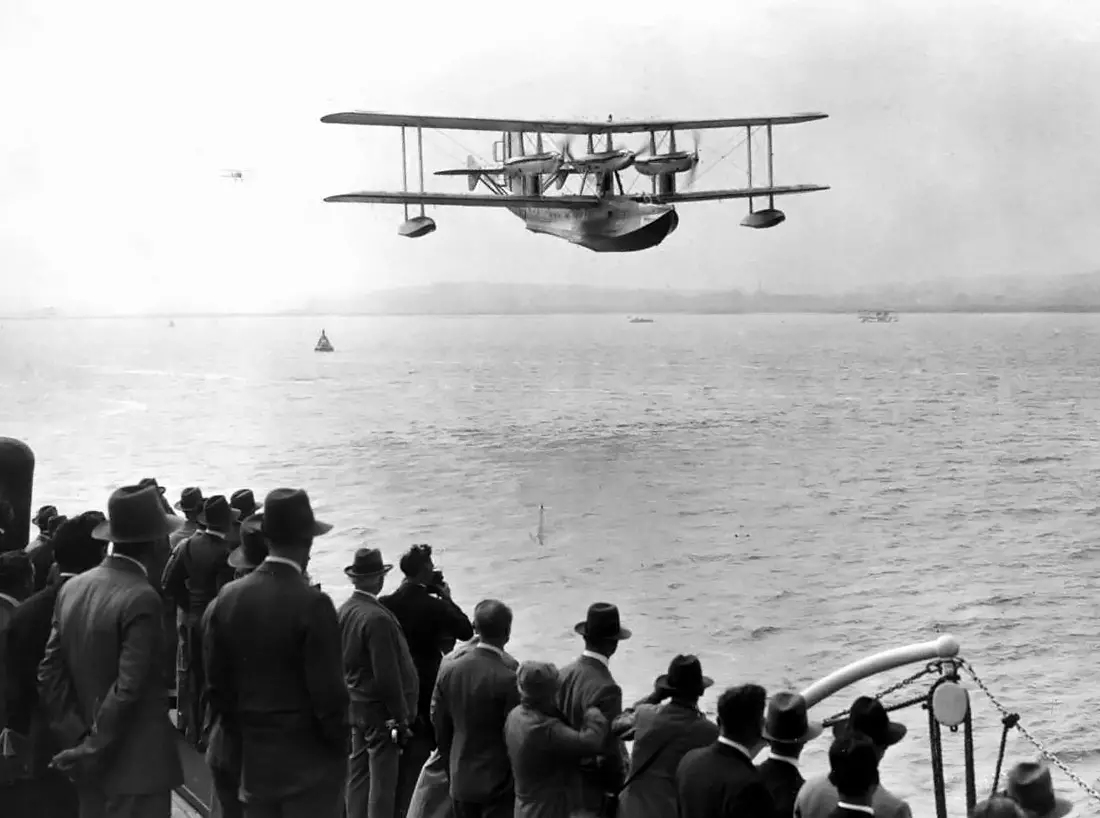 O curto barco de Sarafand voa pasando polos representantes da prensa recollidos o 11 de xullo de 1932 no Stex Queen Steamer. Sobre o hidroavión podes ver outro avión; Á dereita na imaxe podes ver outro barco volador (senta no auga)