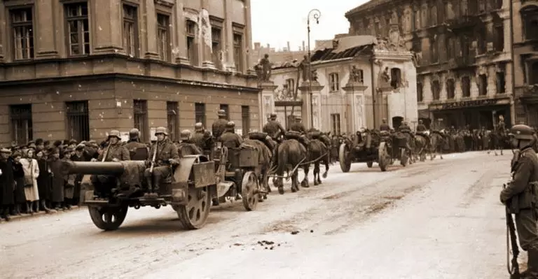 Desfilada de tropes alemanyes a la derrotada Varsòvia, tardor de 1939. Viatges S.F.H. 18 A cavall: en primer pla: el vagó trunny, lluny - el cistell de tubs. Rodes de metall (BundesReshiv)