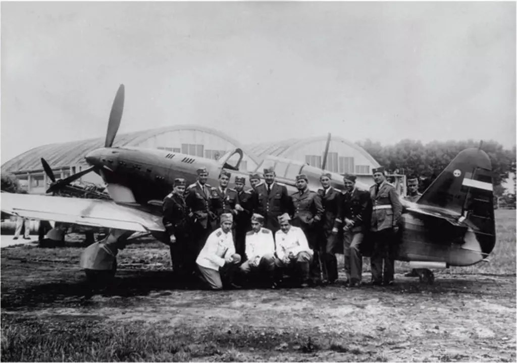 Skupina rezervovaných pilotov je fotografovaná na pozadí IR-3 sériového bojovníka